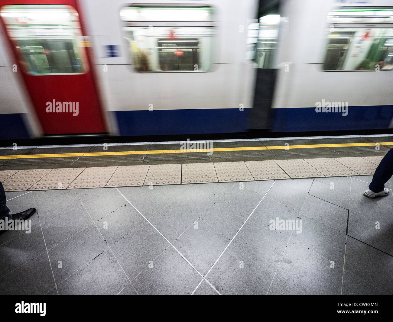 London Underground platform with the blurred image of a moving train ...