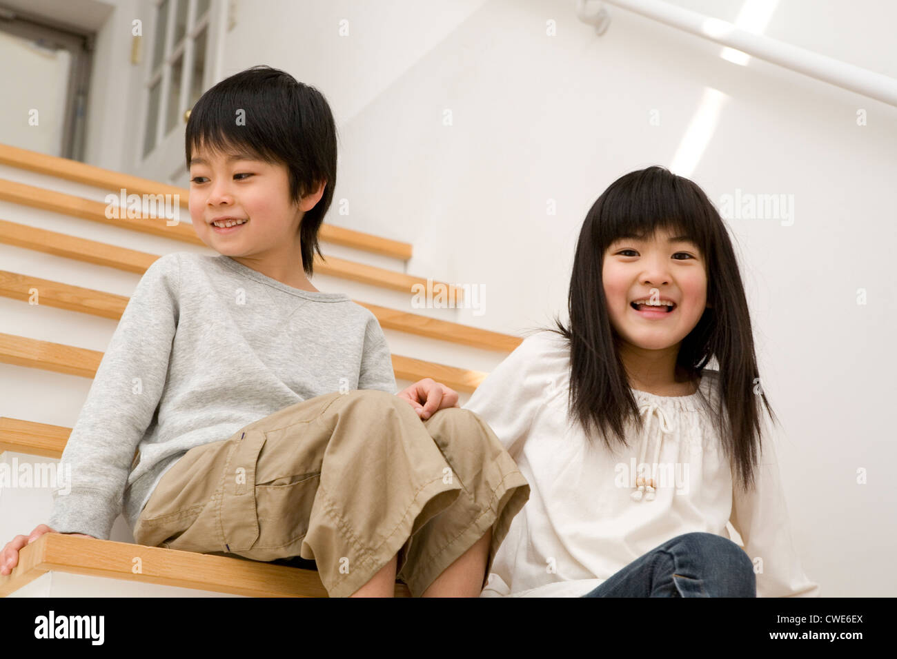 Two kids sitting on stairs Stock Photo - Alamy