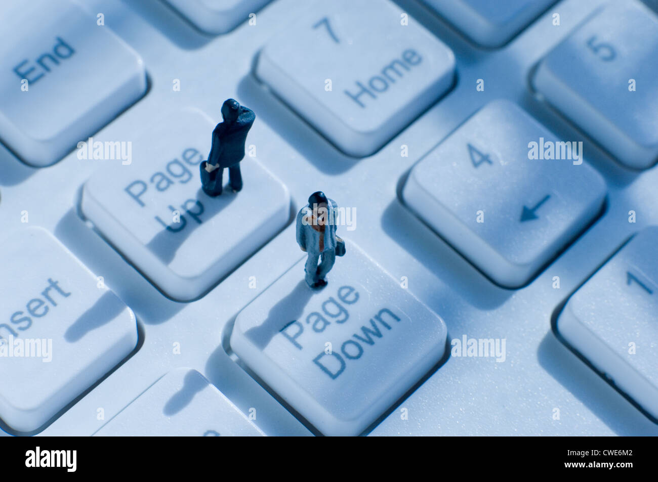 Two Human Figurines On Computer Keyboard Stock Photo - Alamy
