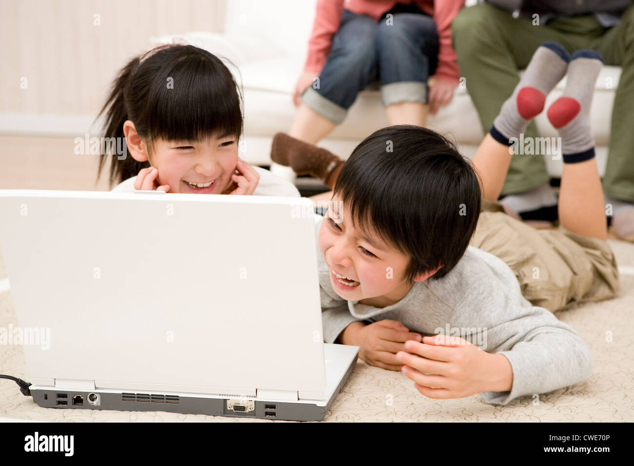 Two children looking laptop and laughing together Stock Photo - Alamy