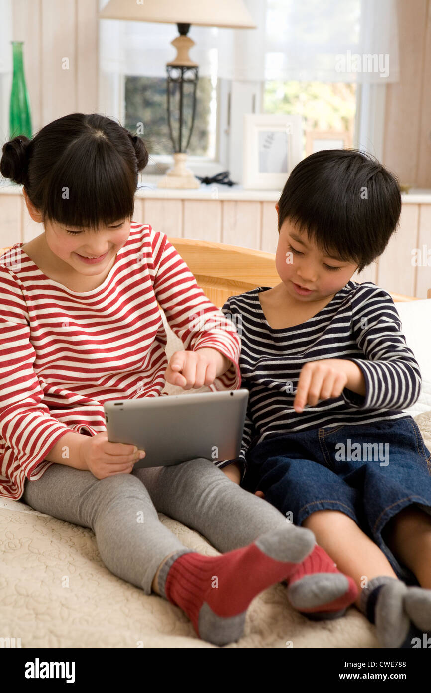 Two kids using tablet computer together Stock Photo - Alamy
