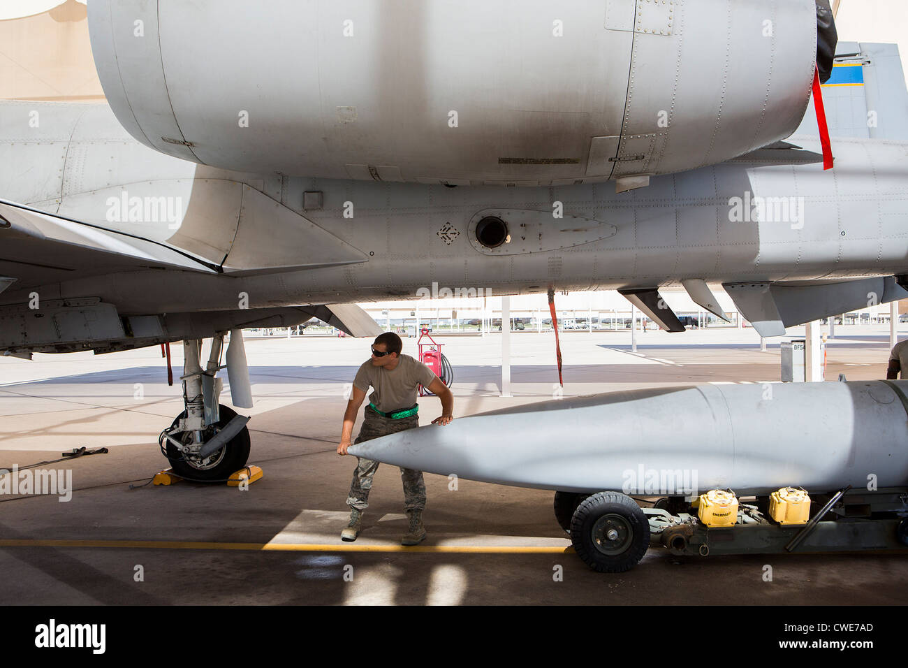 Airmen attach a external fuel tank to an A-10 Thunderbolt from the ...