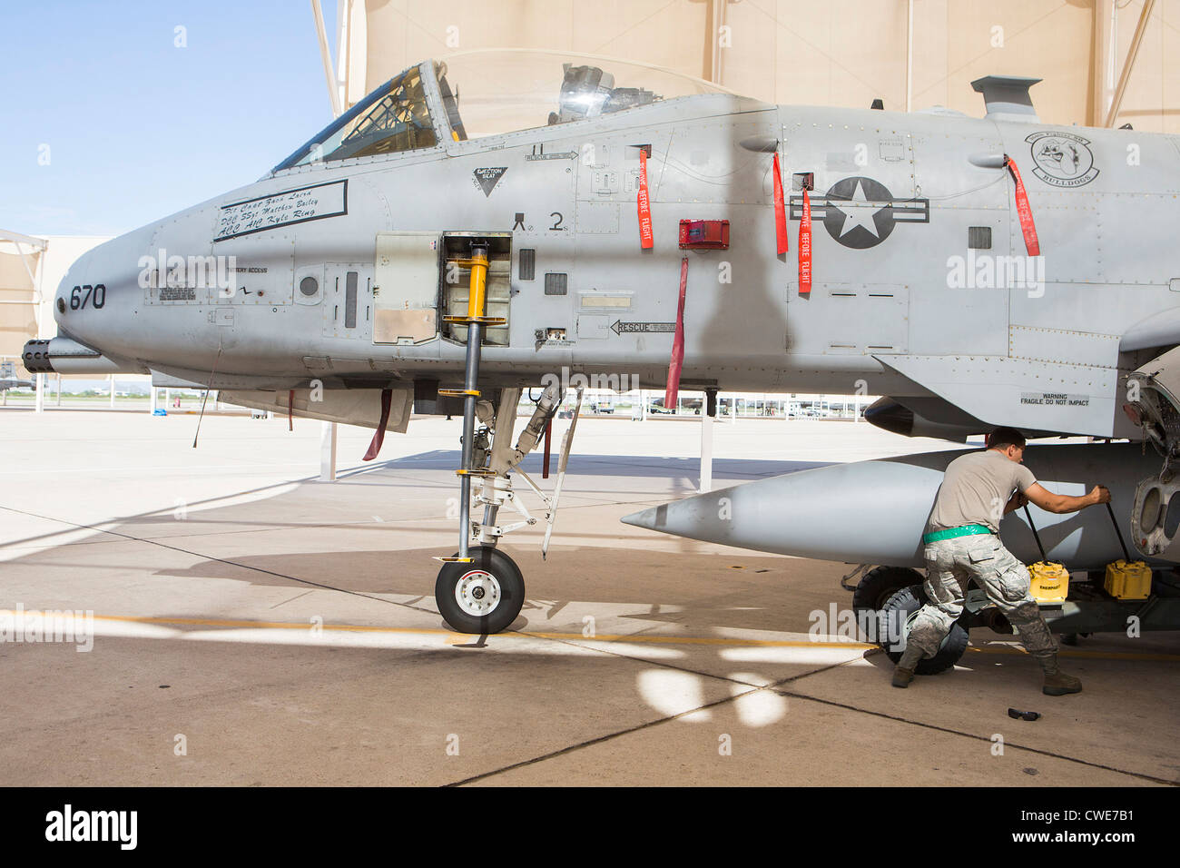 Airmen attach a external fuel tank to an A-10 Thunderbolt from the ...