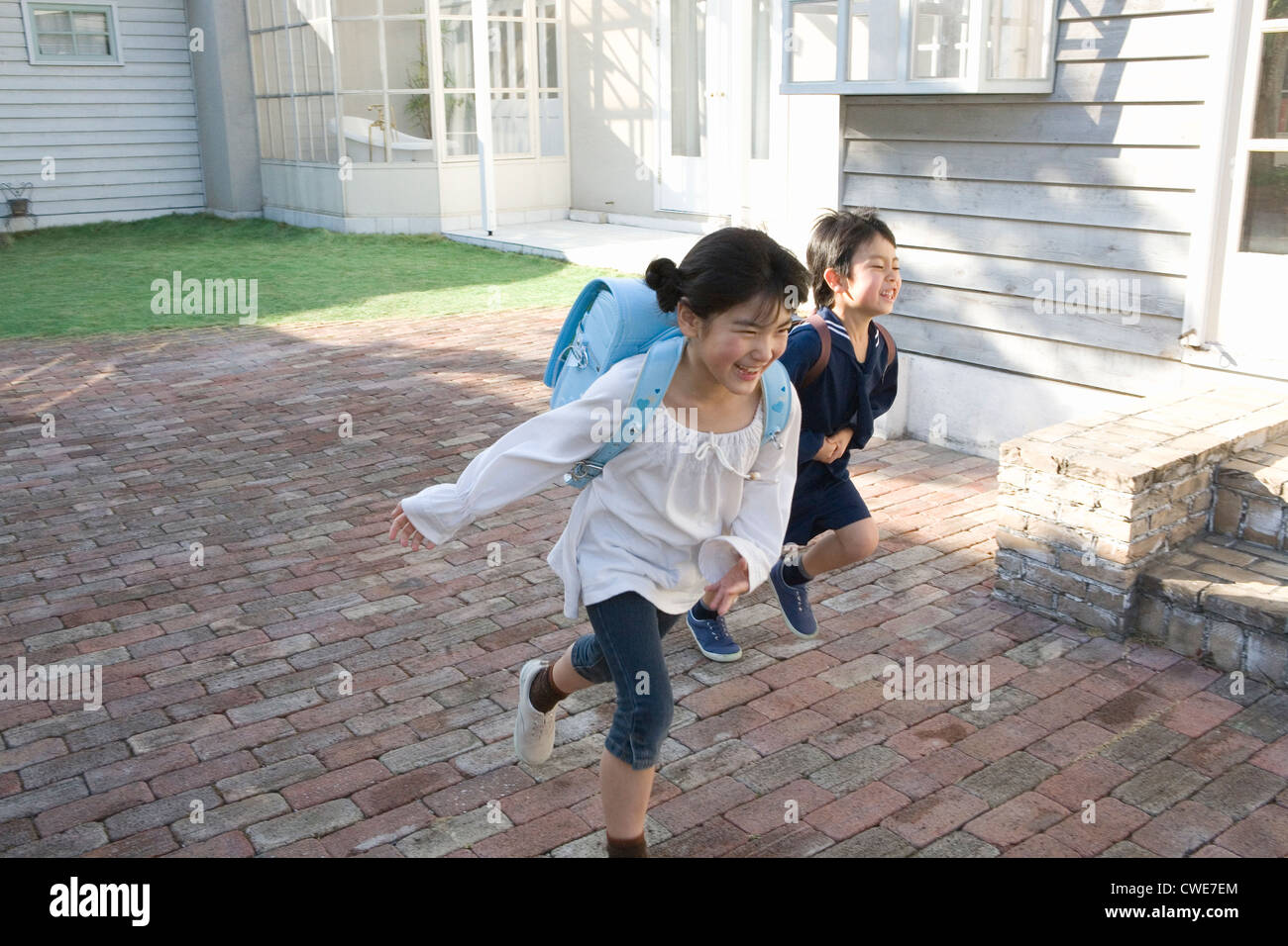 Two kids running on front yard Stock Photo - Alamy