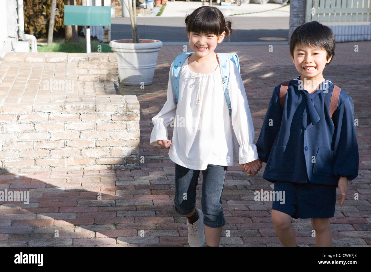 Two kids walking on front yard Stock Photo - Alamy