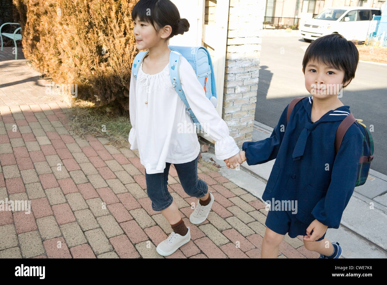 Two kids walking on front yard Stock Photo - Alamy