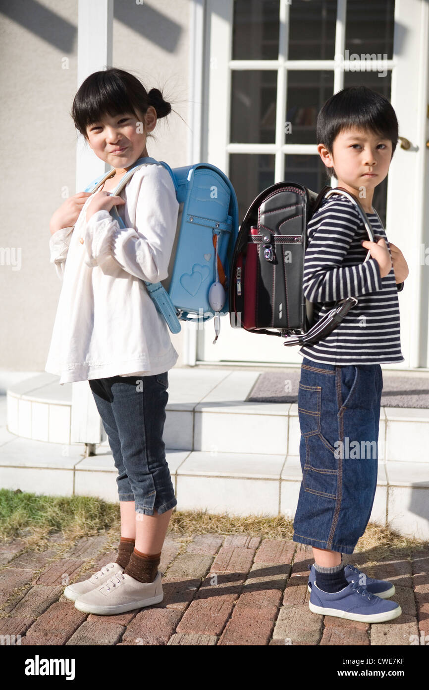 Two kids standing on front yard Stock Photo - Alamy
