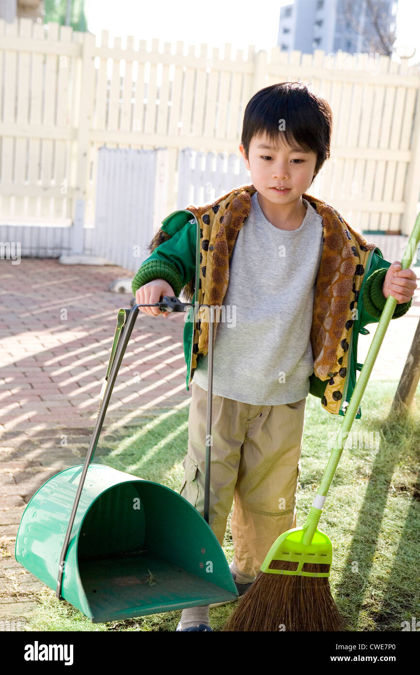 Boy cleaning up front yard Stock Photo - Alamy