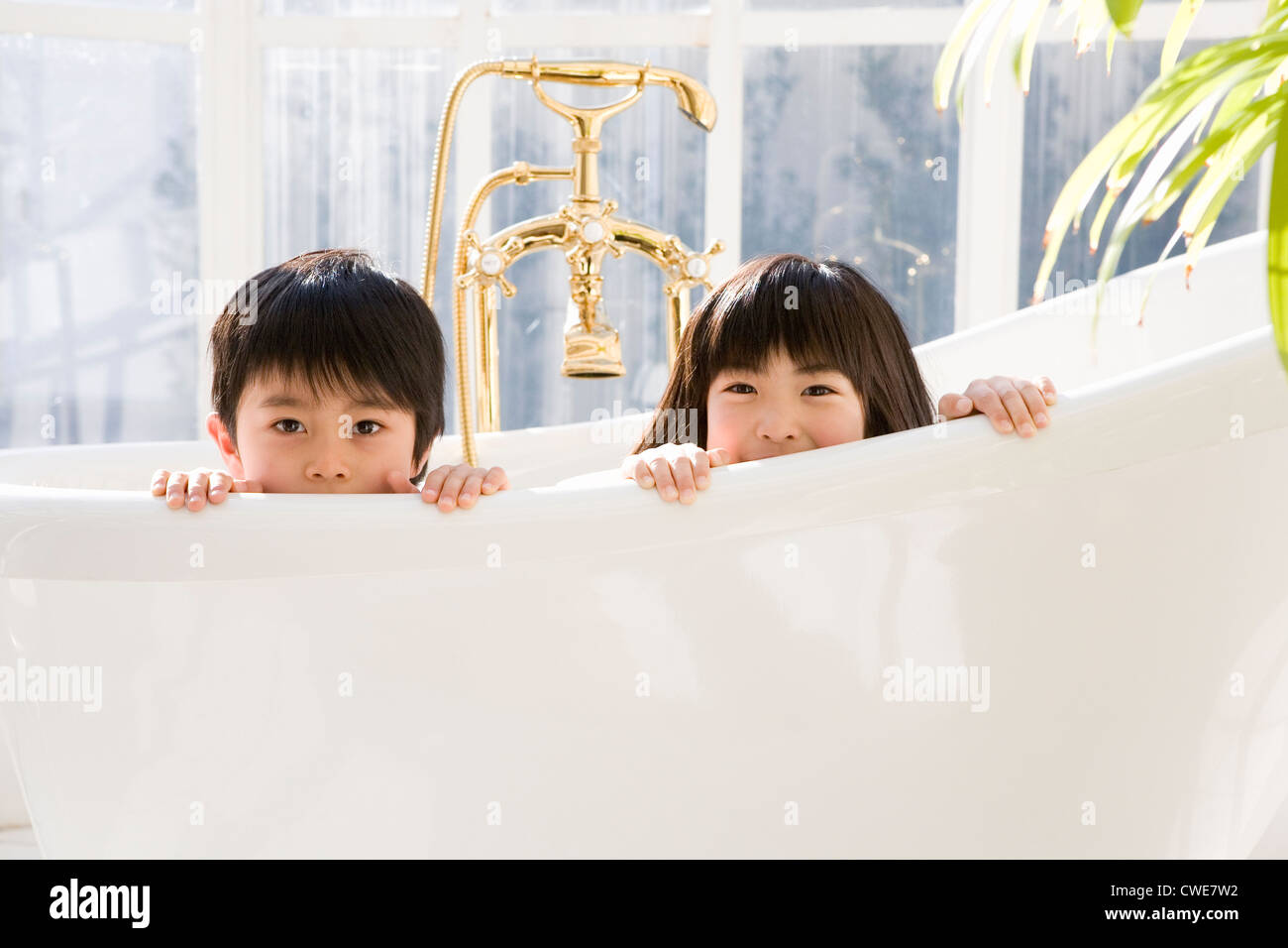 Two children playing in bathtub Stock Photo - Alamy