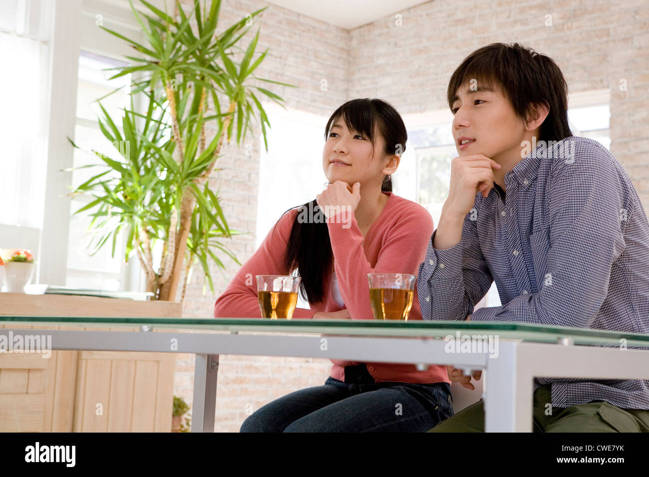 Young couple sitting at dining table Stock Photo - Alamy