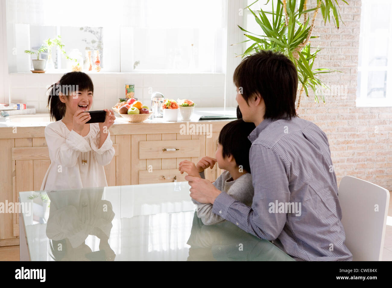 Daughter taking photograph of family with smartphone Stock Photo - Alamy