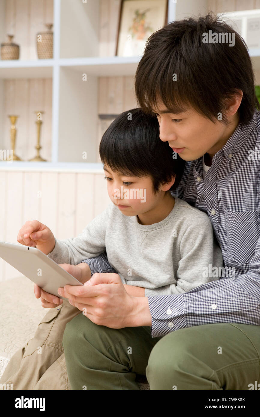 Father and son using tablet computer Stock Photo - Alamy