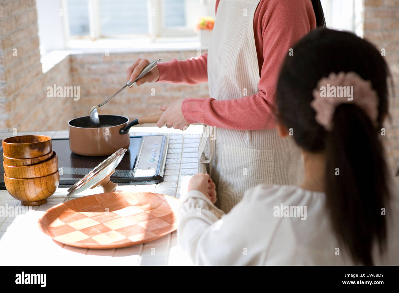 Mother and daughter standing at kitchen Stock Photo - Alamy