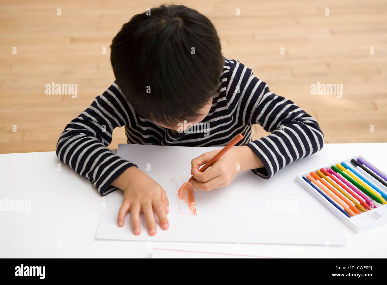 Boy sitting and drawing picture Stock Photo - Alamy