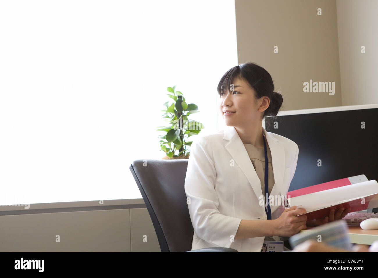 Businesswoman looking back at office Stock Photo - Alamy