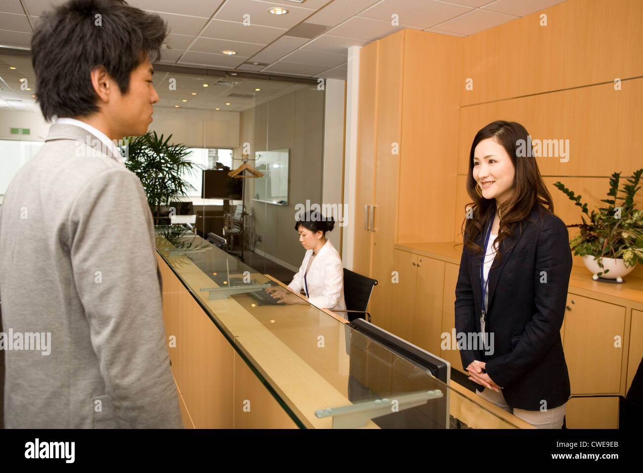 Businesswoman receiving visitor Stock Photo - Alamy