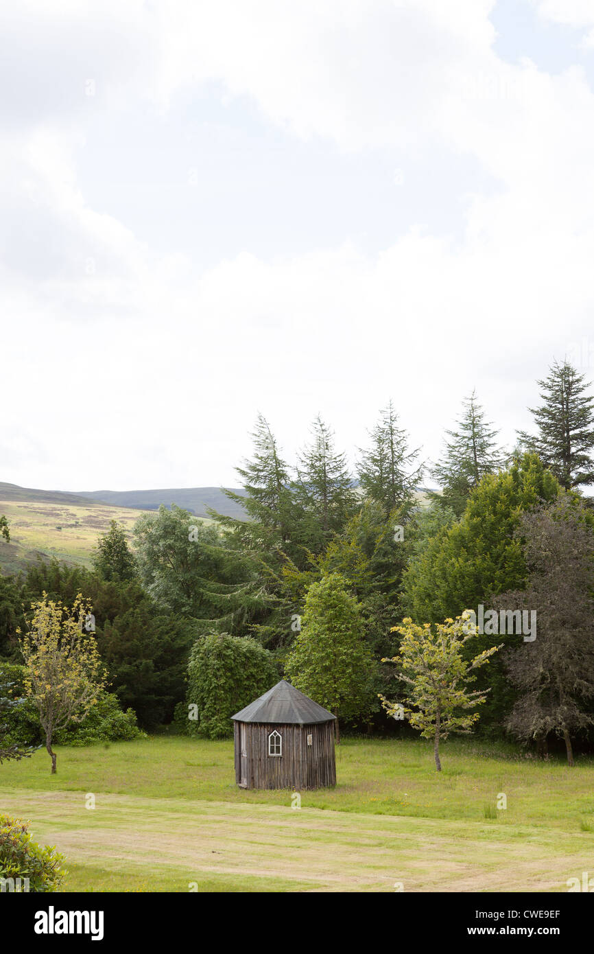 small hut in field surrounded by trees Stock Photo - Alamy