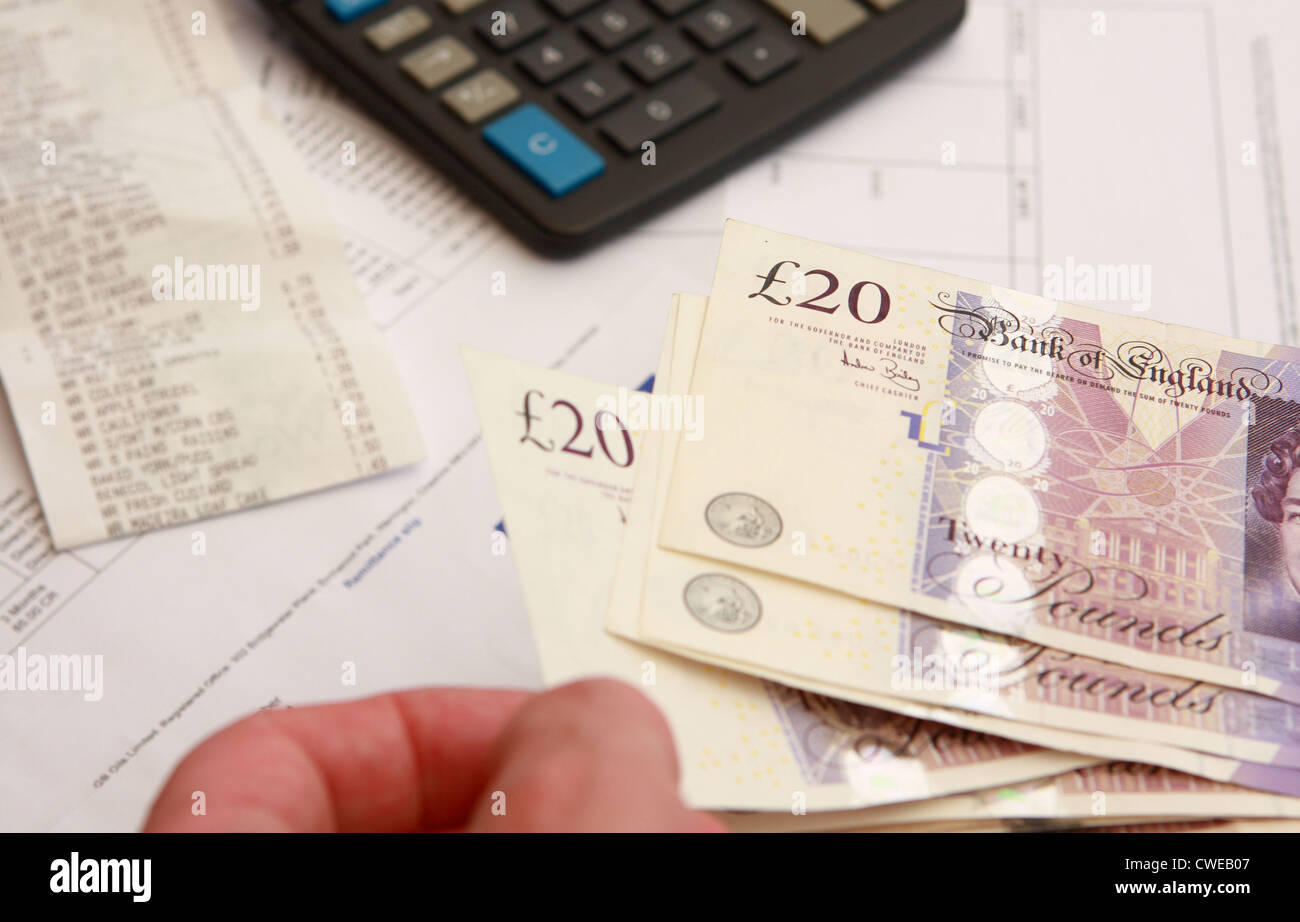 part of a hand pulling a £20 note from a bundle of notes with a ...