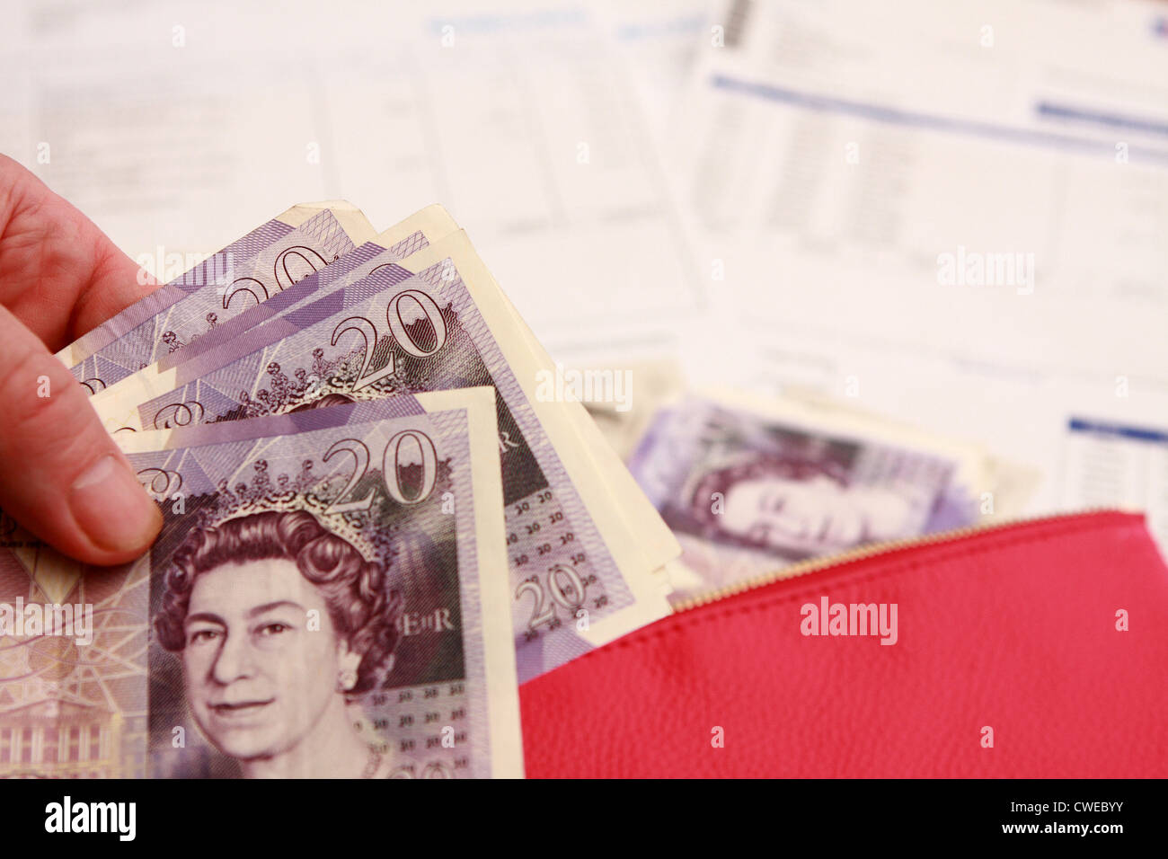 a hand holding £20 notes with a purse, a £20 note and other out of ...