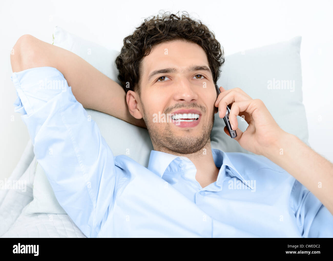 Young handsome man talking on modern mobile phone. Studio shot Stock ...