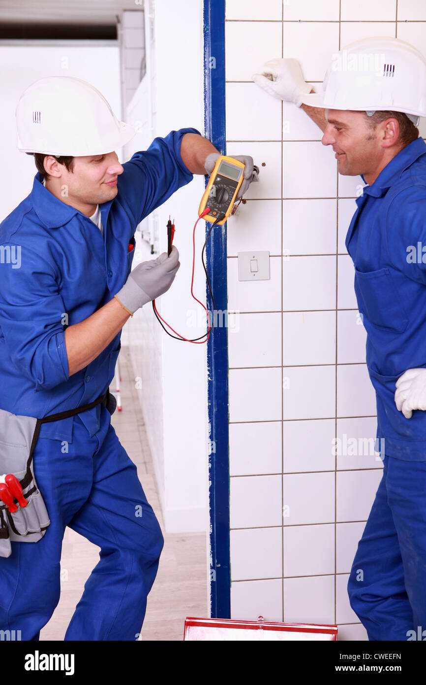 Two electricians discussing a voltmeter Stock Photo - Alamy