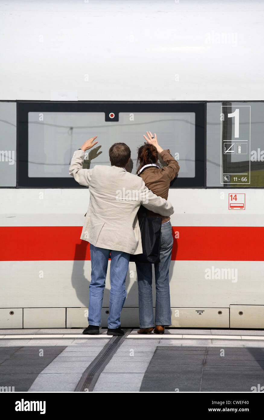 Couple waving goodbye at the window of a train Stock Photo - Alamy