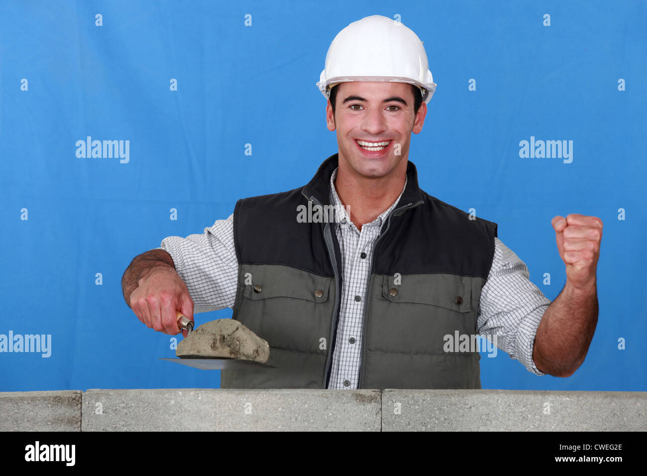 Portrait of a mason busy constructing a wall Stock Photo - Alamy