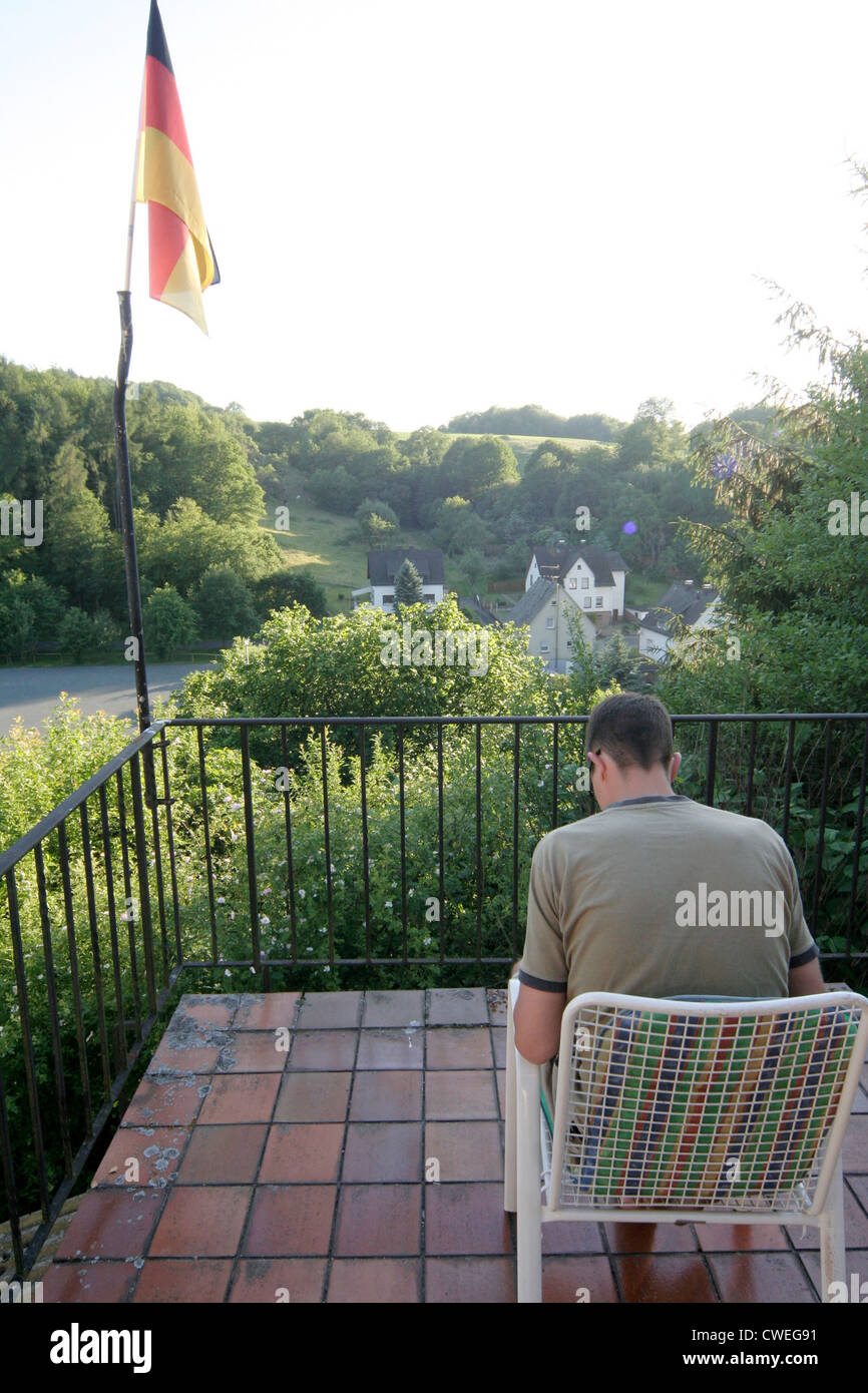 Young man sitting on a terrace Stock Photo - Alamy