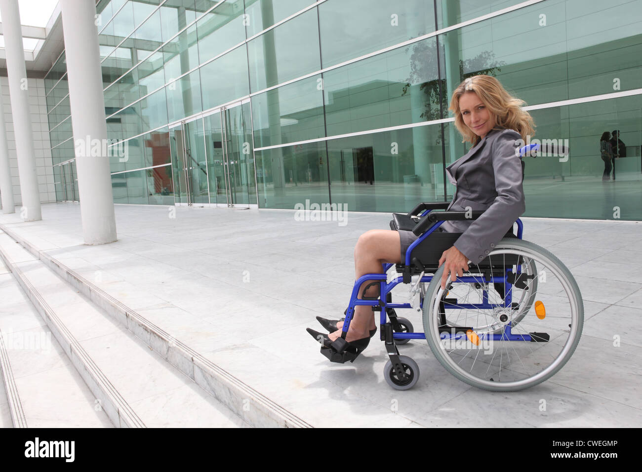 Businesswoman in wheelchair outside office block Stock Photo - Alamy