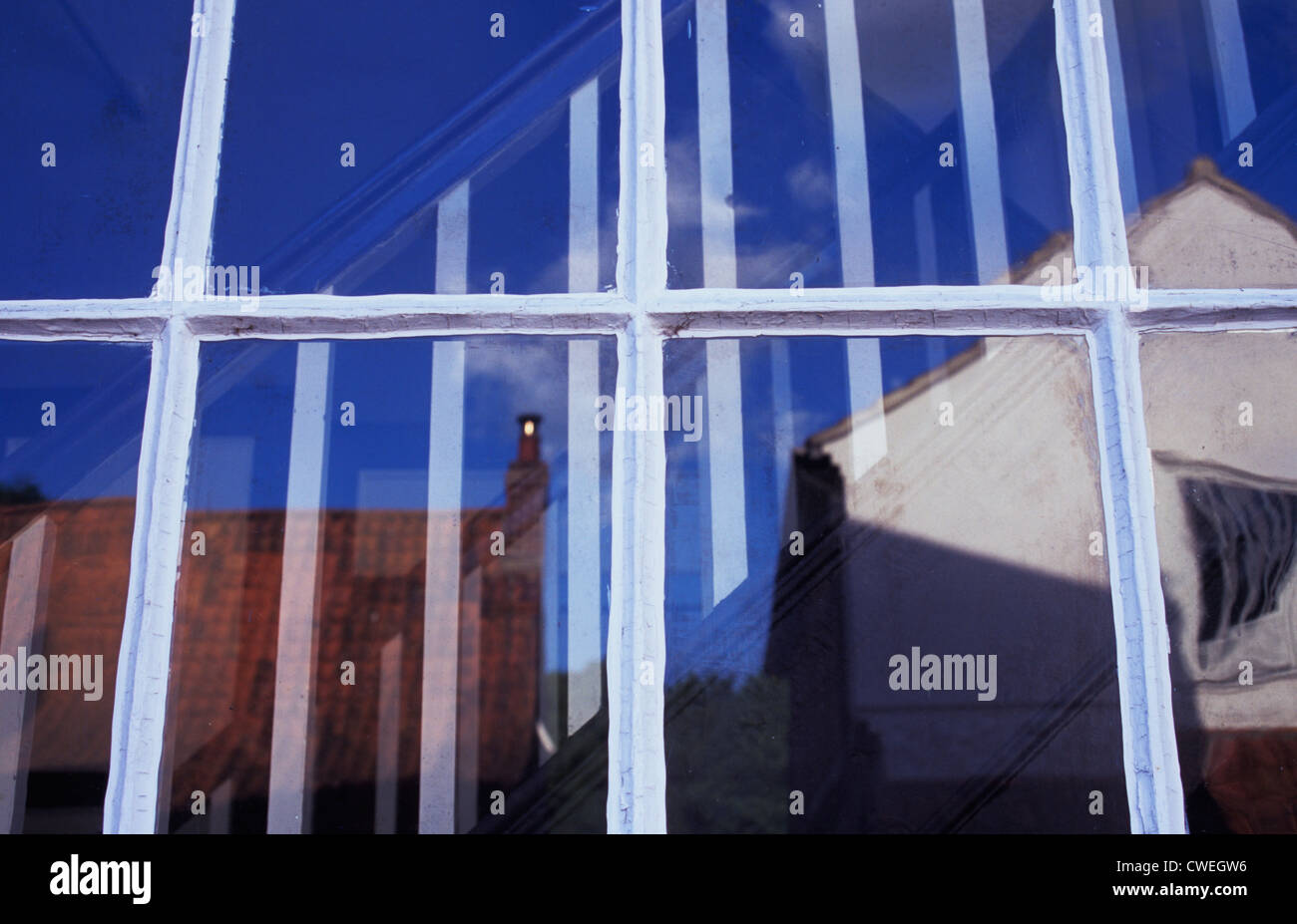 Detail of window divided into small panes with view of stair banister ...