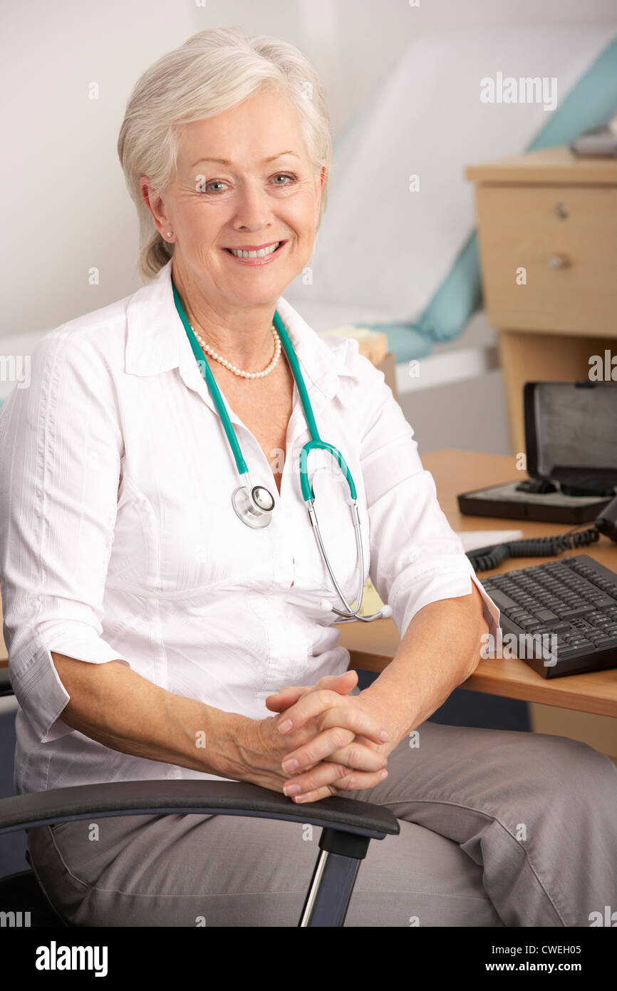 British female GP sitting at desk Stock Photo - Alamy