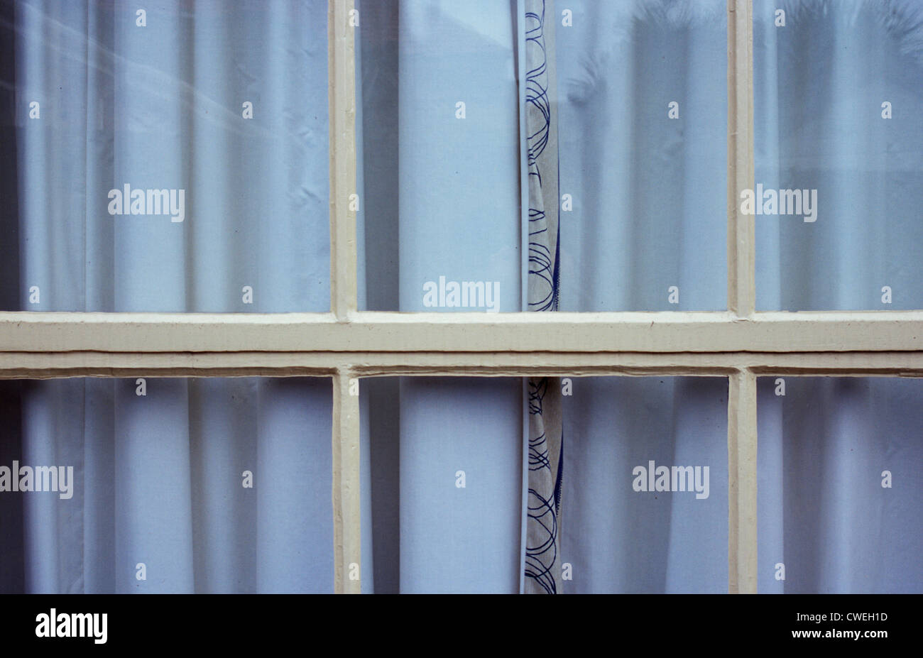 Detail of smart window divided into small panes with lined curtains ...
