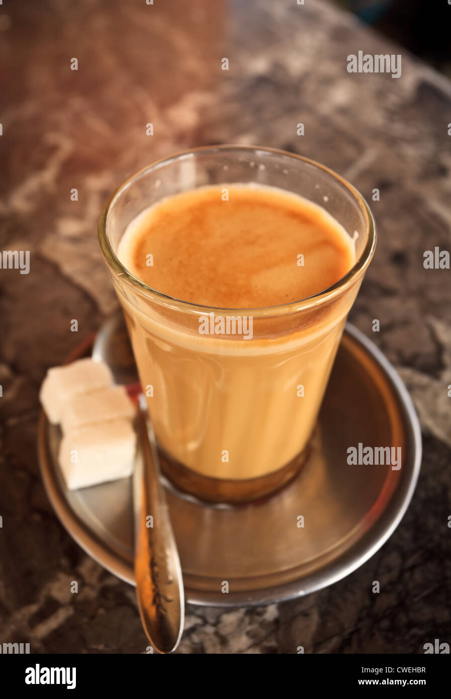 Closeup of a Cup of chai tea and sugar cubes sitting on a table at a ...