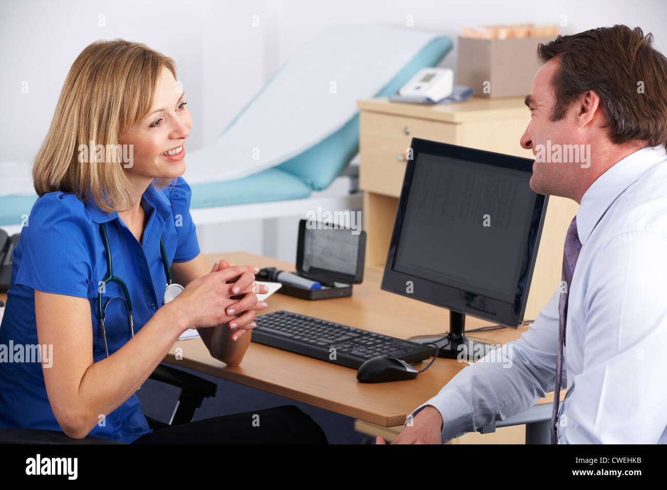 Female UK doctor talking to male patient Stock Photo - Alamy