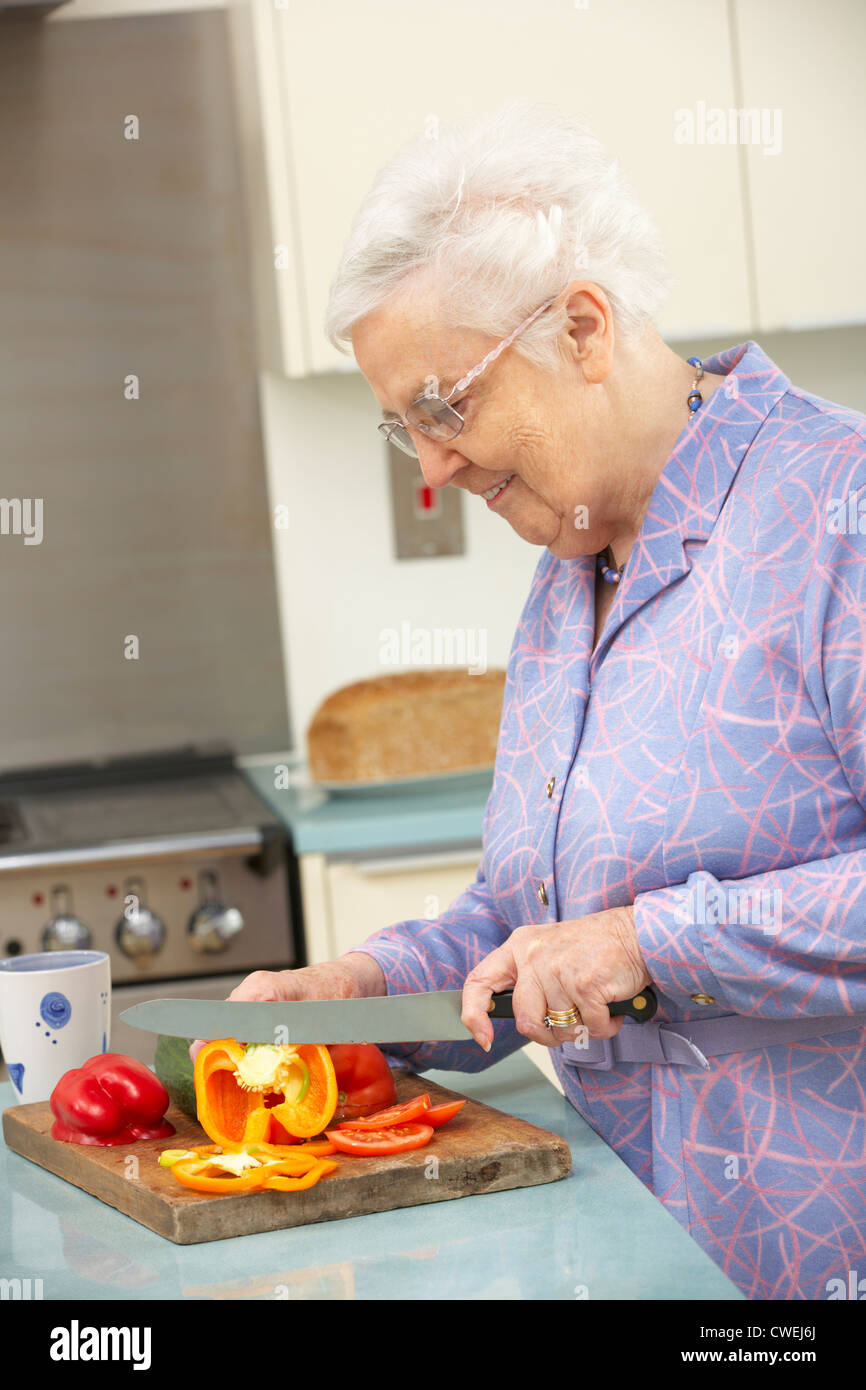 Senior woman chopping vegetables in domestic kitchen Stock Photo - Alamy