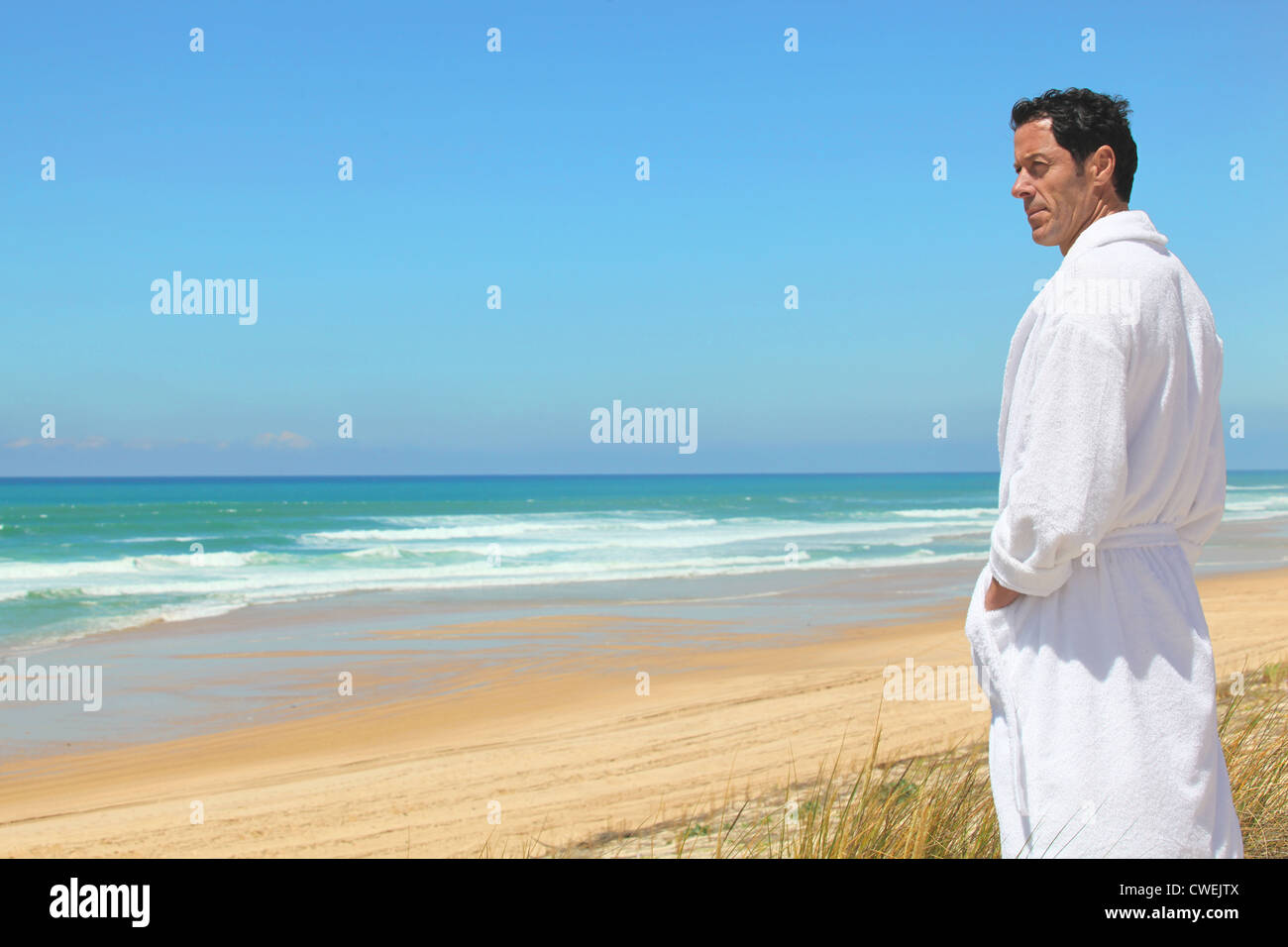 Man in bathrobe on the beach Stock Photo - Alamy