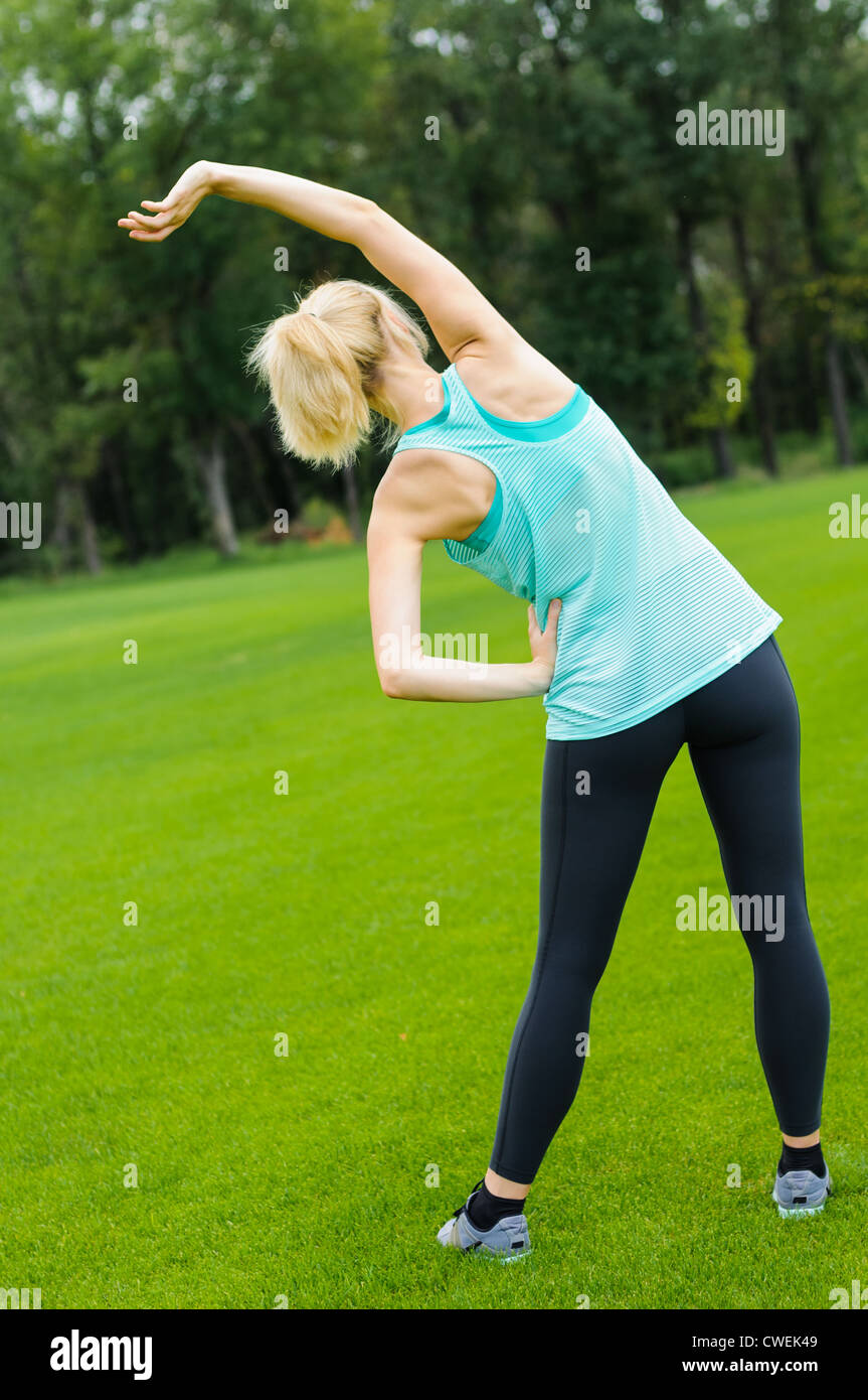 Woman doing stretches in park hi-res stock photography and images - Alamy