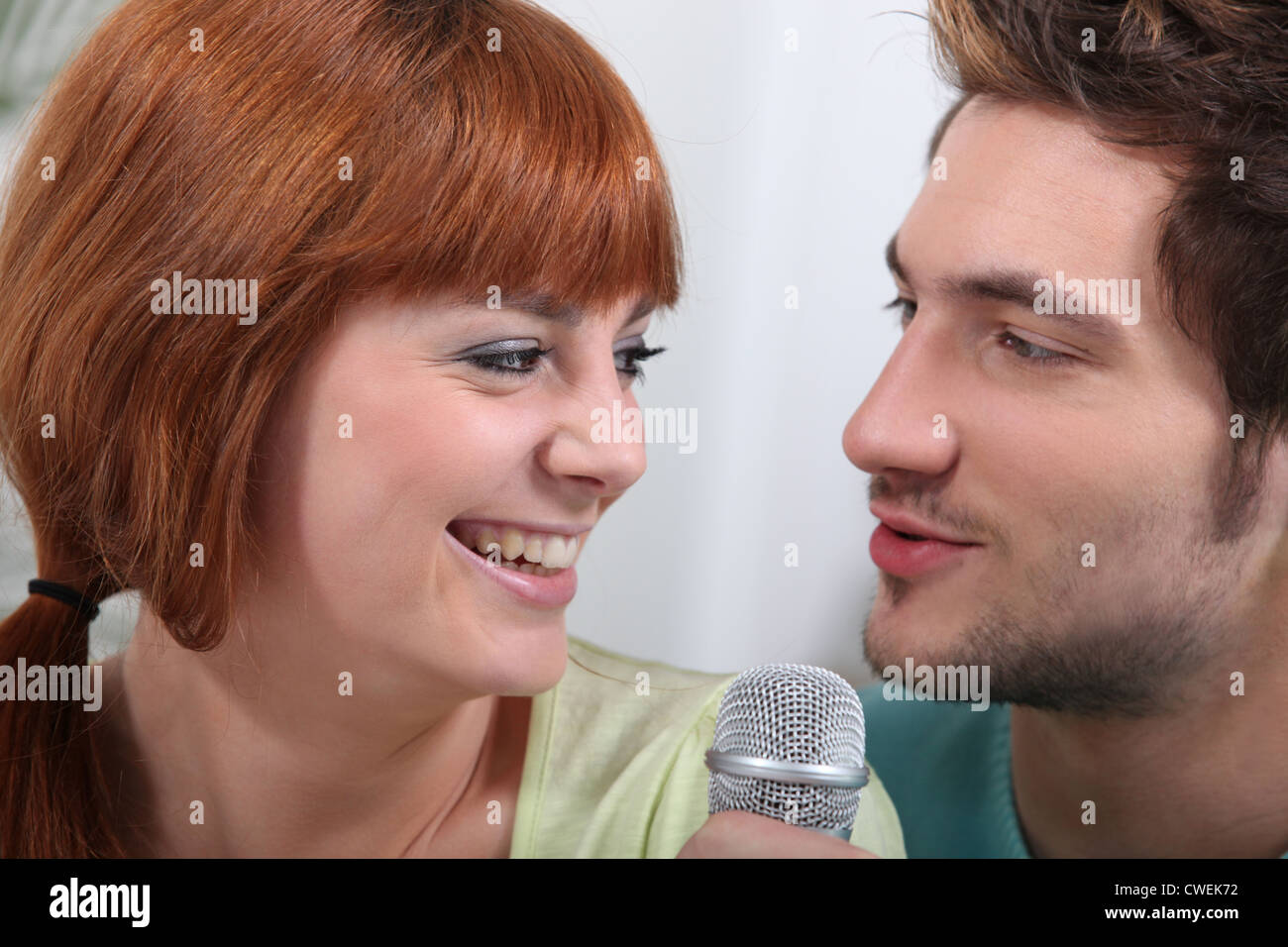 Couple singing with microphone Stock Photo - Alamy