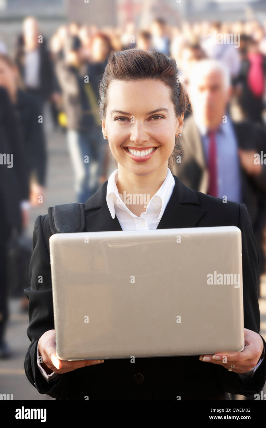 Female commuter in crowd using laptop Stock Photo - Alamy