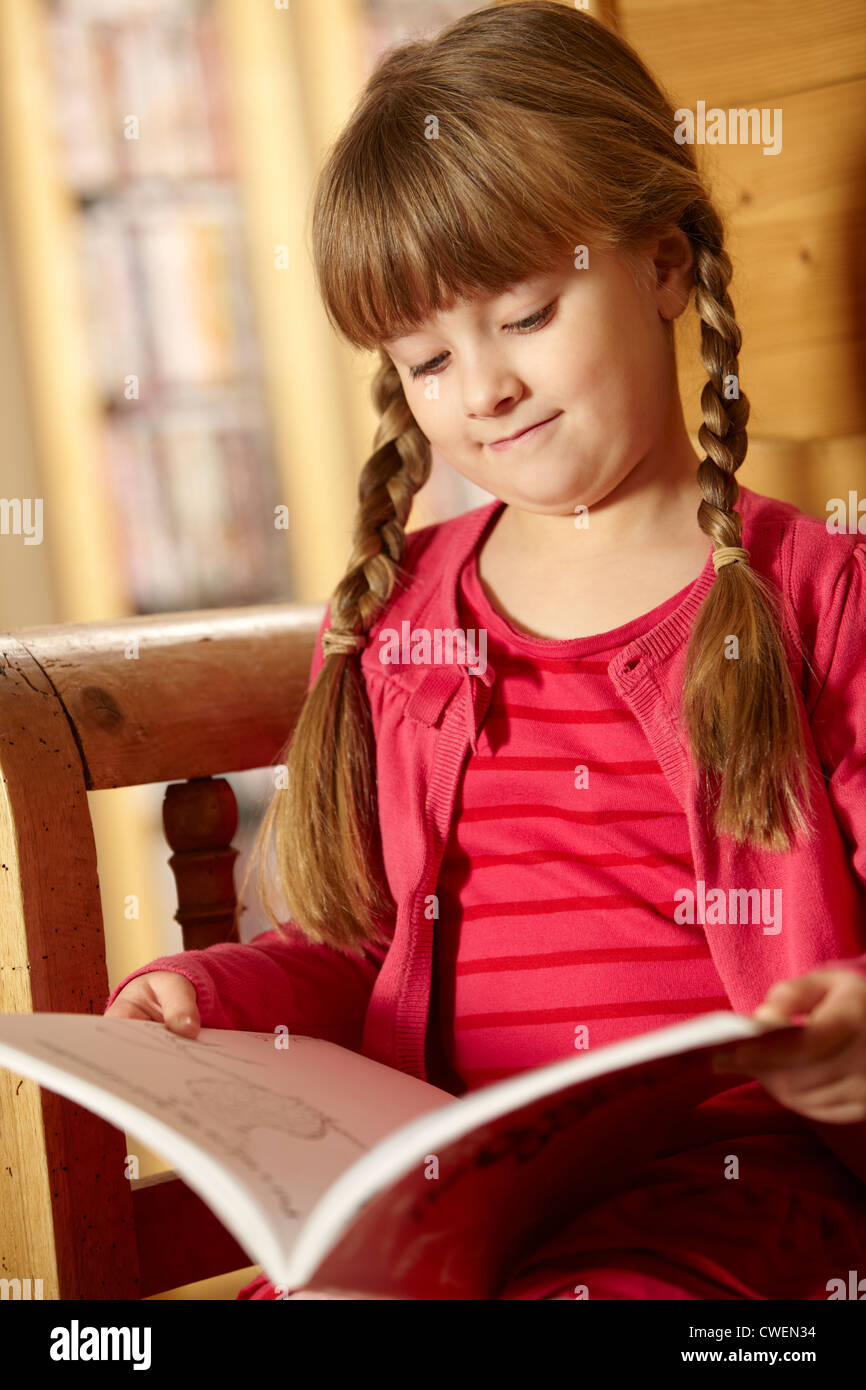Young Girl Sitting On Wooden Seat Reading Book Stock Photo - Alamy