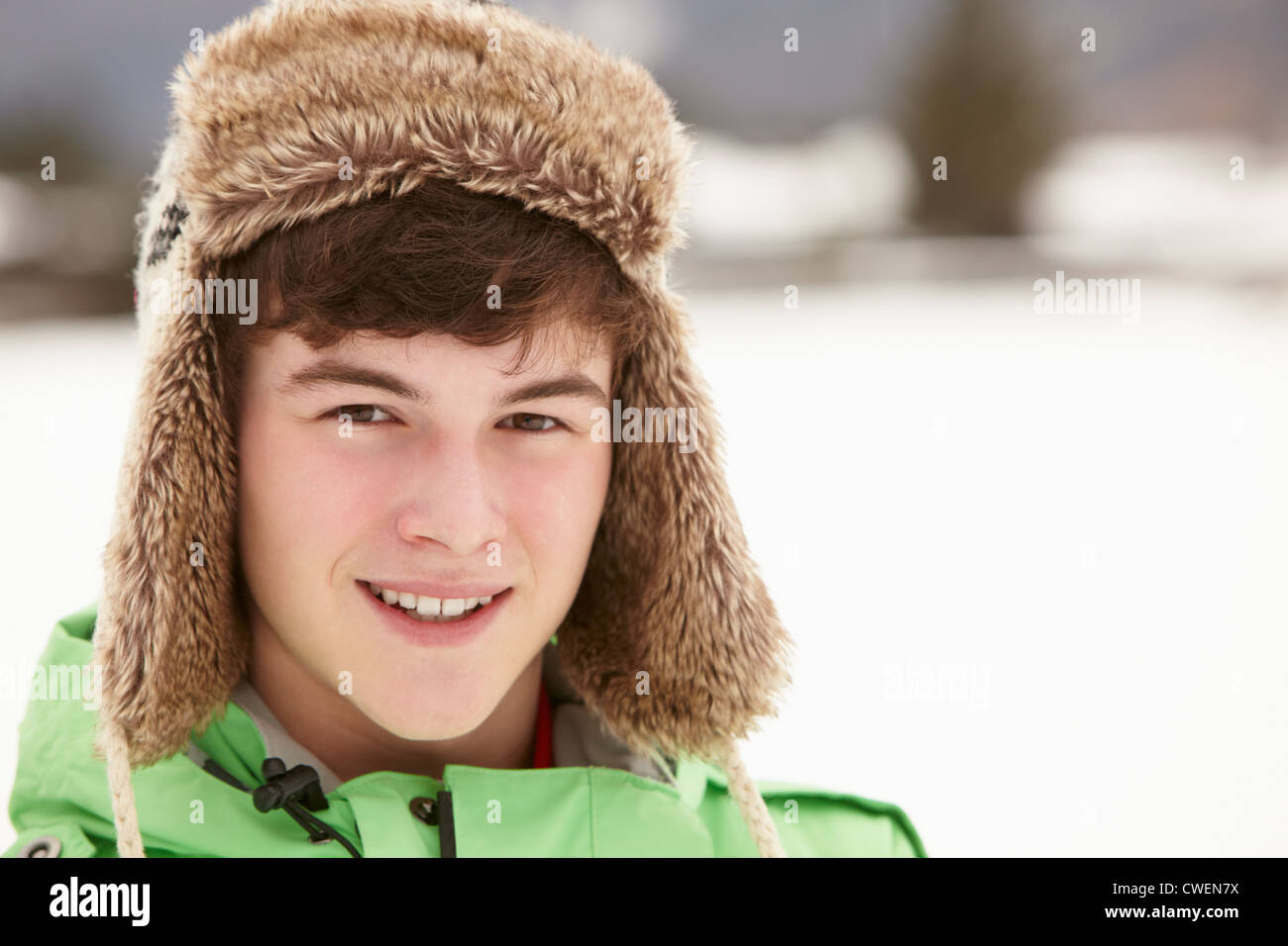 Portrait Of Teenage Boy In Snow Wearing Fur Hat Stock Photo - Alamy