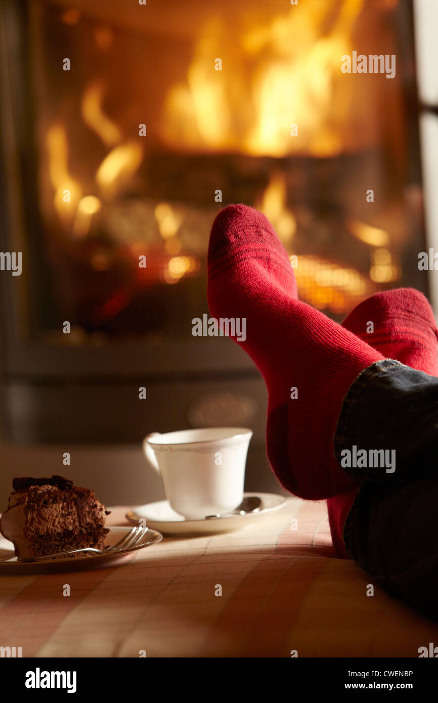 Close Up Of Mans Feet Relaxing By Cosy Log Fire With Tea And Cake Stock ...