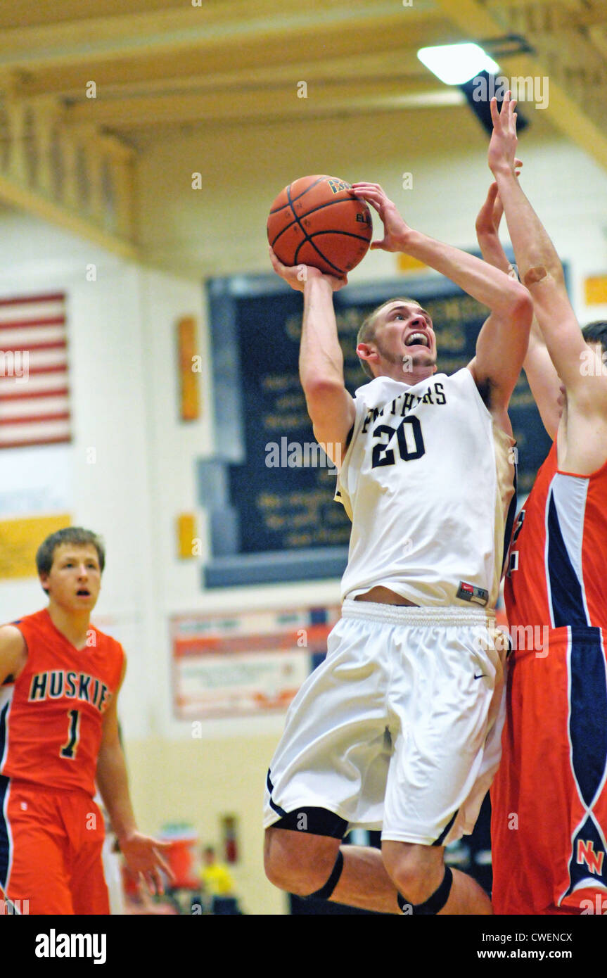 Basketball Player leaves the hardwood to get off a shot while dealing ...