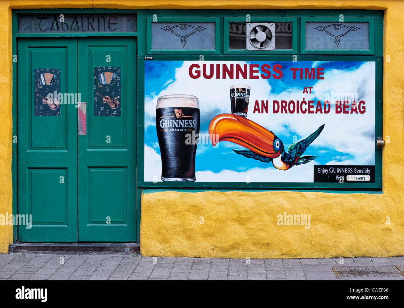 Guinness sign with Toucan on The Small Bridge pub wall, Dingle, County ...