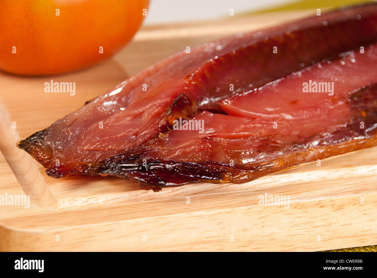 A piece of dry bonito, also known as little tunny, on a chopping board ...