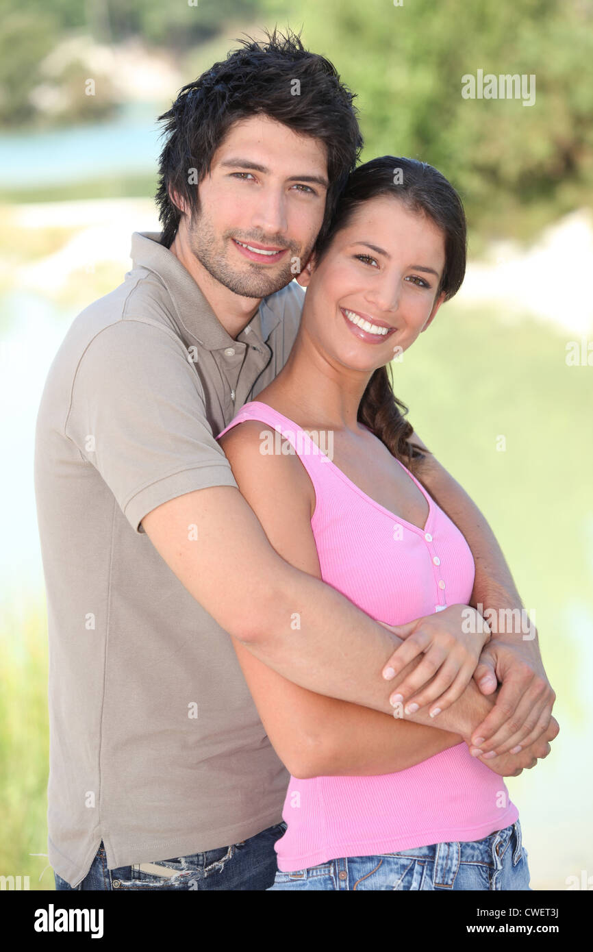Couple hugging in field Stock Photo - Alamy