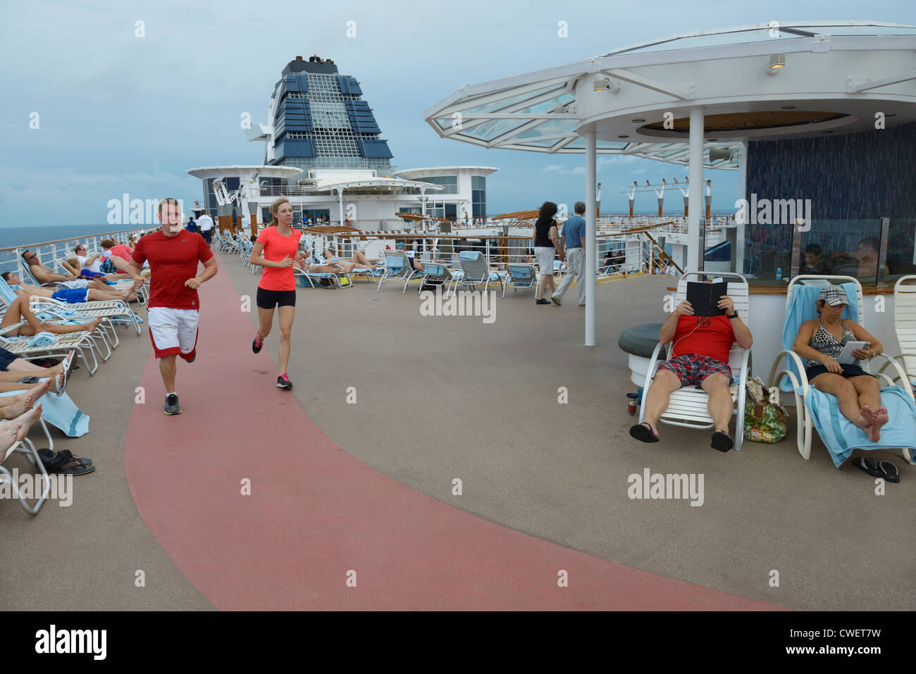 Top deck of a cruise ship with runners and people relaxing Stock Photo ...