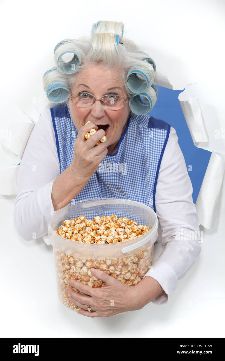 Elderly lady eating popcorn Stock Photo - Alamy