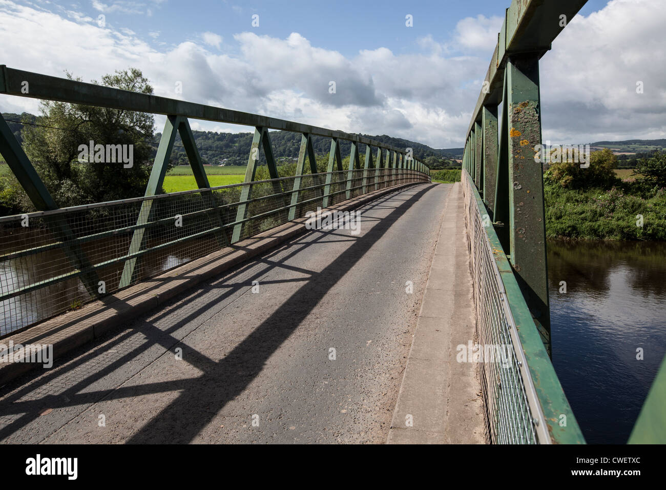 A metal road bridge crosses a stretch of the River Wye running in the ...