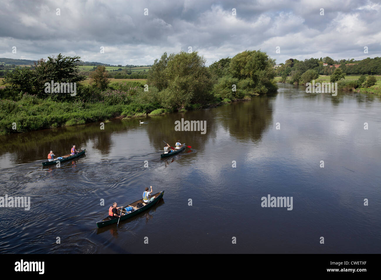 A metal road bridge crosses a stretch of the River Wye running in the ...